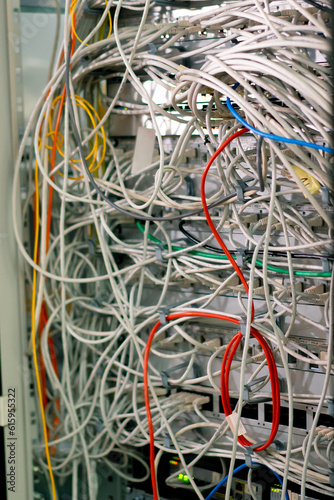 a bunch of patch network cables sorted in a rack cabinet leading from a ...