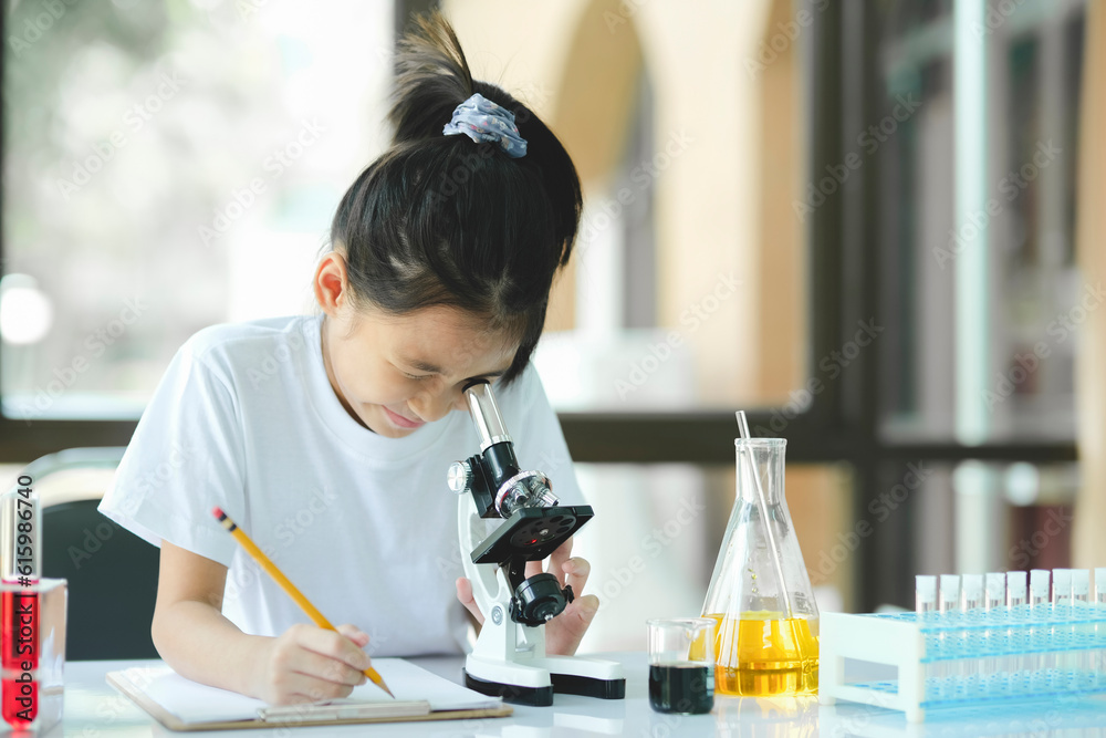 Little child with learning class in school laboratory using microscope ...