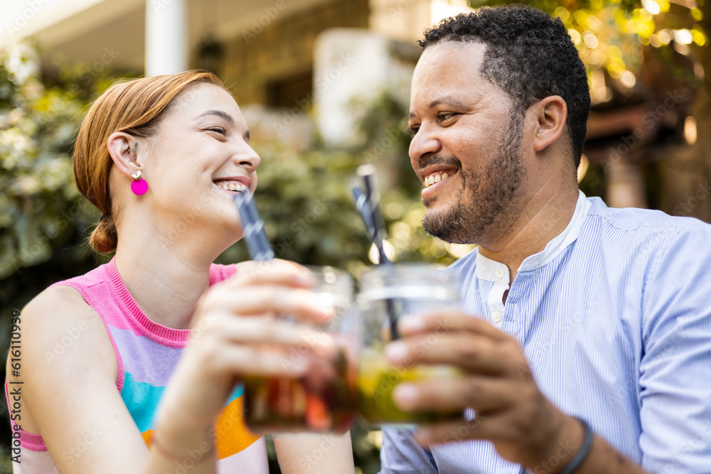 A Multiracial Couple Have Fun Drinking Mojitos Happily In An Outdoor