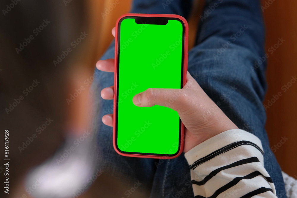 Teenage girl of 12 years with backpack holds a mobile phone green ...