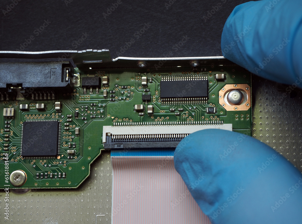 Engineer plugs flexible flat cable into socket into the socket on board ...