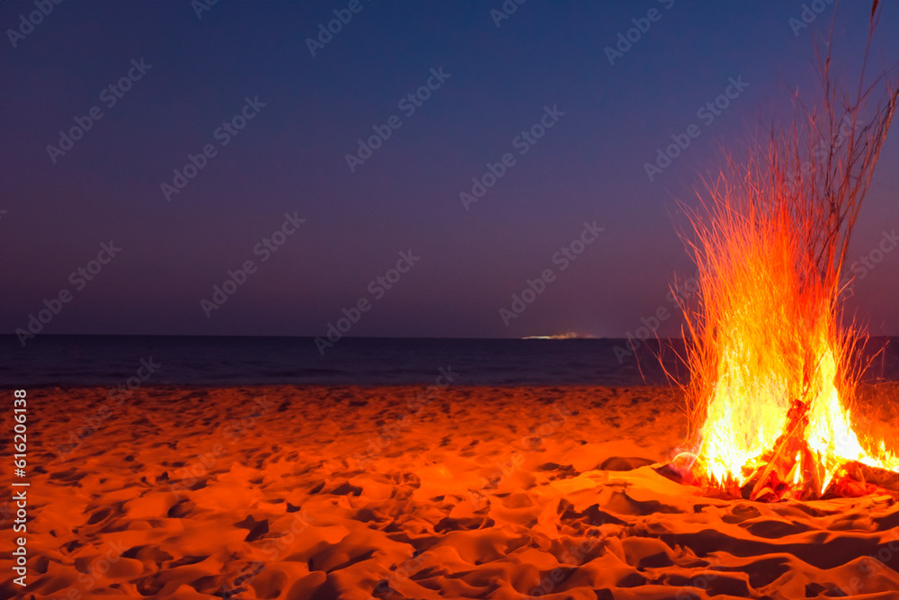 Bonfire. Small campfire with gentle flames beside a lake during a ...
