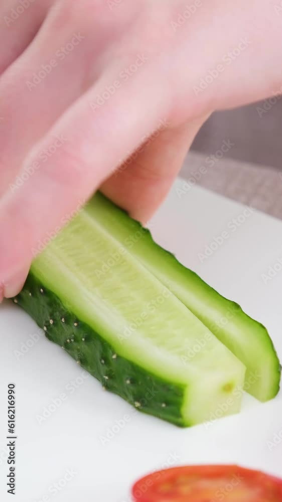 close-up beautiful female young hands cut cucumber with big knife on ...