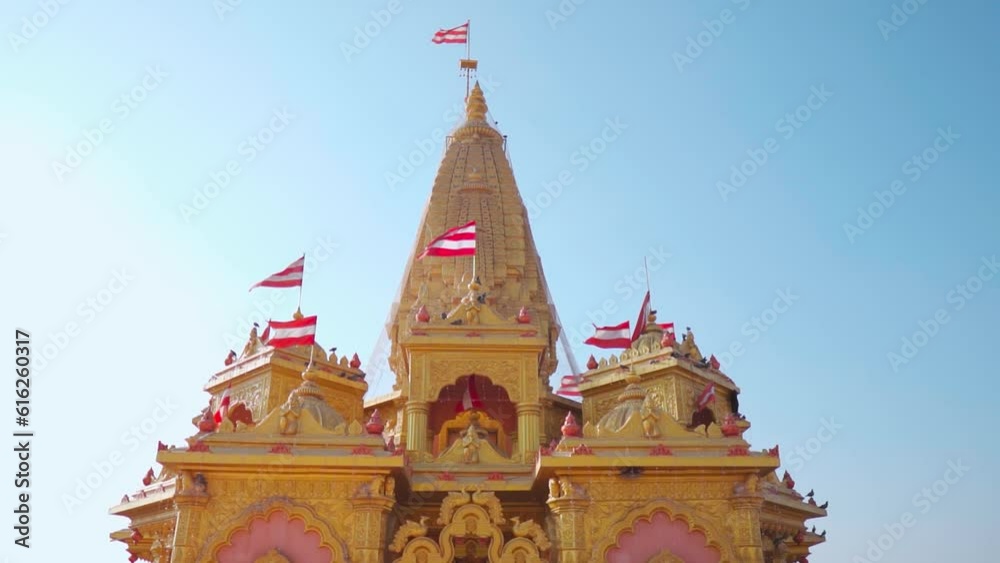 Beautiful golden Swaminarayan temple of Varnindradham with flags waving ...