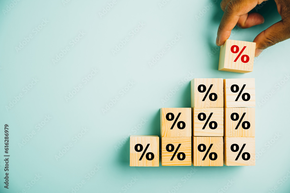 Concept of interest rate and financial rates. Hand placing a wooden ...