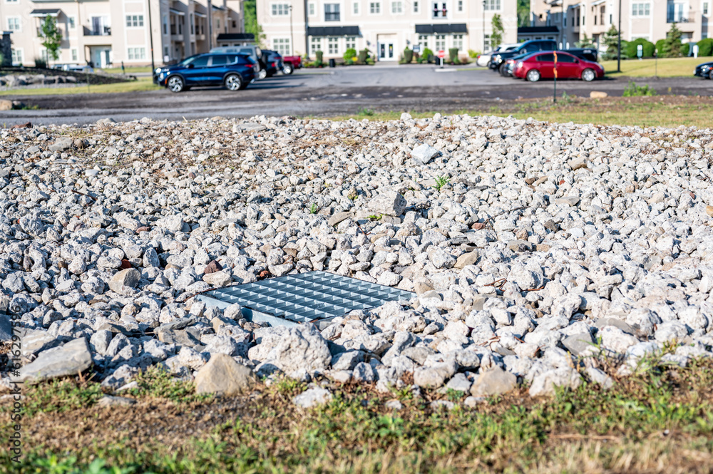Grated storm drain inlet surrounded by rock for soil erosion control ...