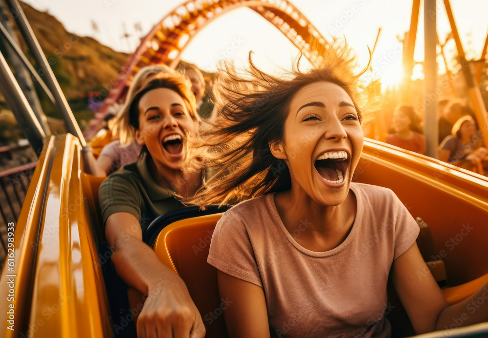 People cheering and enjoying a roller coaster ride at the amusement ...