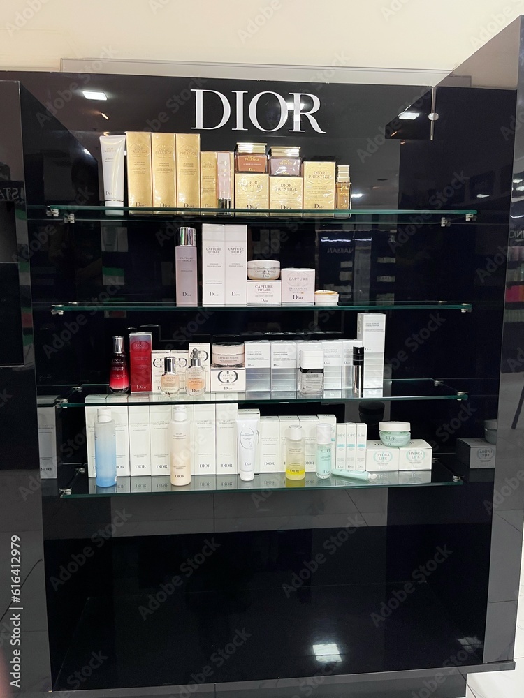Foto de Shelf with luxury Dior brand goods. Branded rack in store in ...