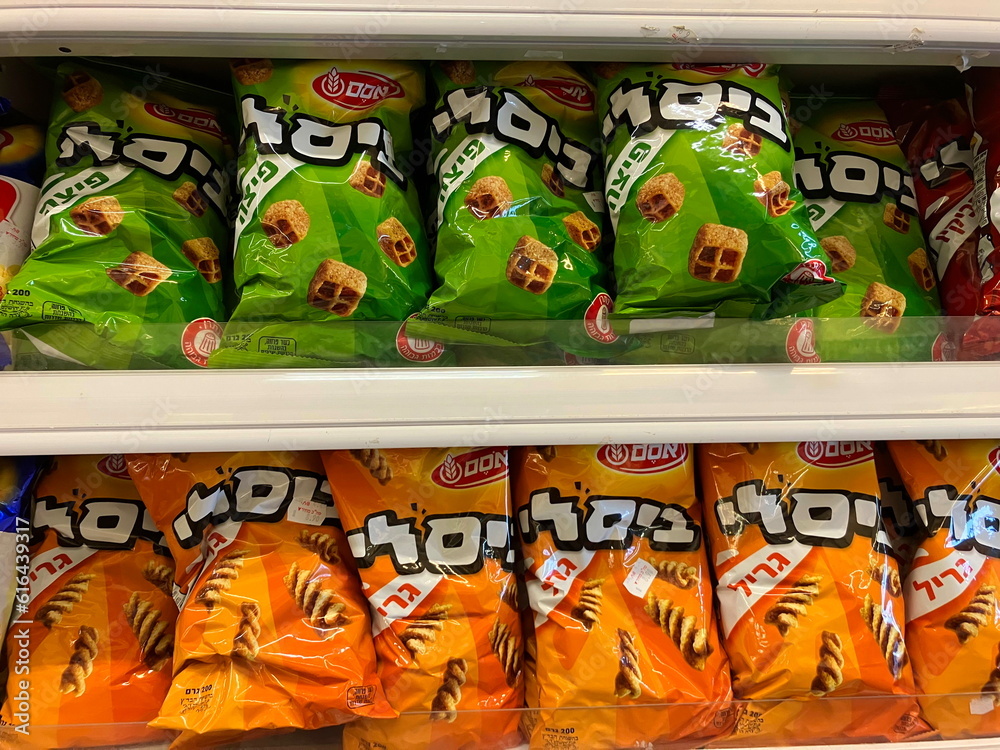 Display with snacks in a store. Translation: Bissli, chips, bamba ...