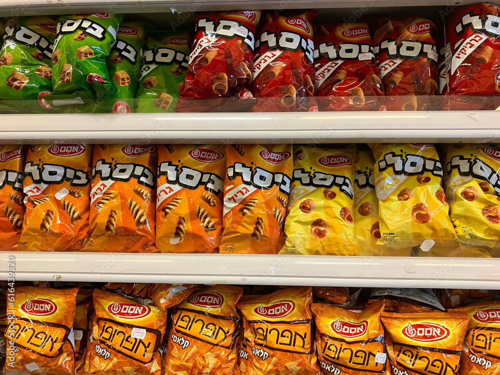 Display with snacks in a store. Translation: Bissli, chips, bamba ...
