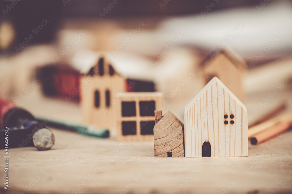 small and big wooden house on builder table with tools for build new ...