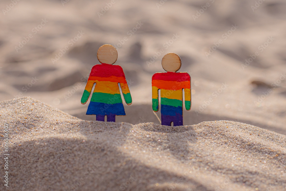 LGBT wooden people on the beach on the sand. Couple standing on beach ...