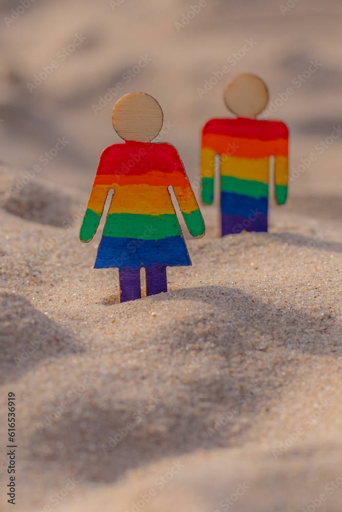 LGBT wooden people on the beach on the sand. Couple standing on beach ...