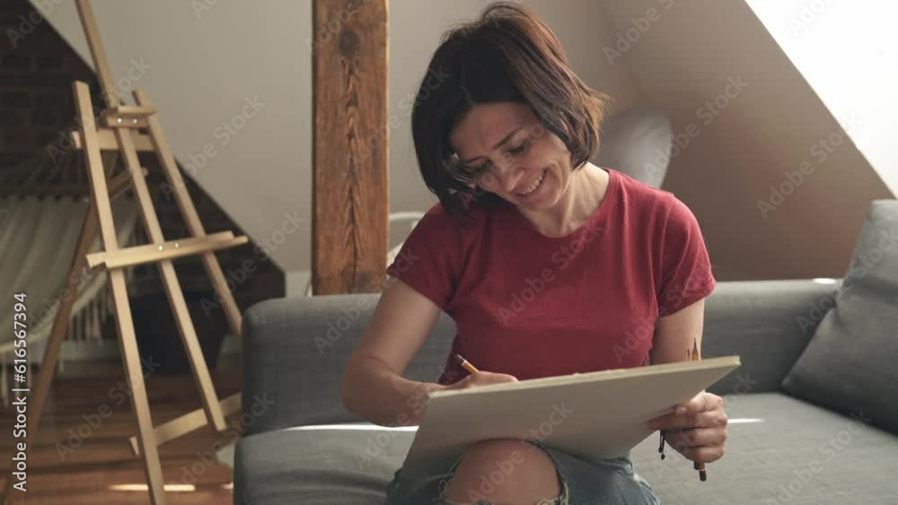 Pretty girl artist holding canvas and drawing sketch with pencil at ...