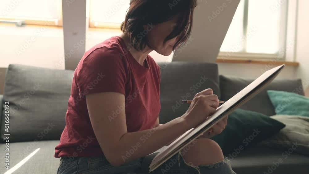 Pretty girl artist holding canvas and drawing sketch with pencil at ...