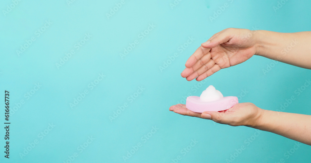 Hands washing gesture with pink sponge and foaming hand soap on mint ...