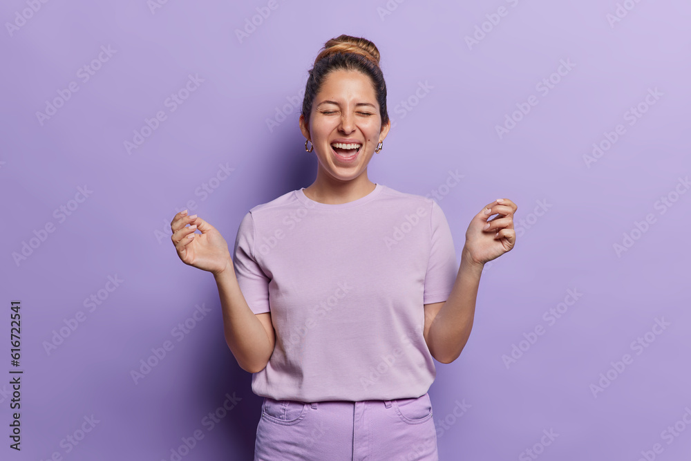 Overjoyed young female model exclaims loudly expresses her happiness ...