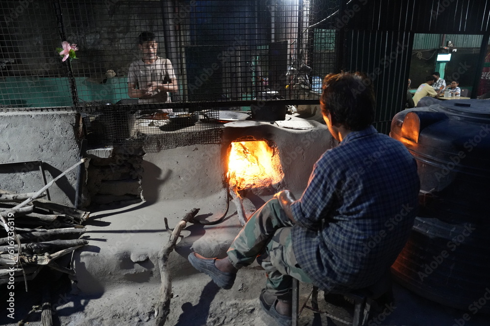 Preparing meals using a mud chula and wood fire Stock Photo | Adobe Stock
