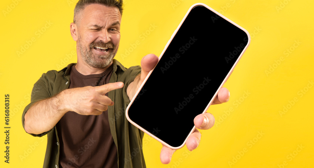 Excited bristle middle-age man holding big smartphone with blank screen ...