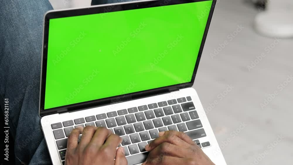 Black man using laptop notebook viewing green screen press keyboard ...