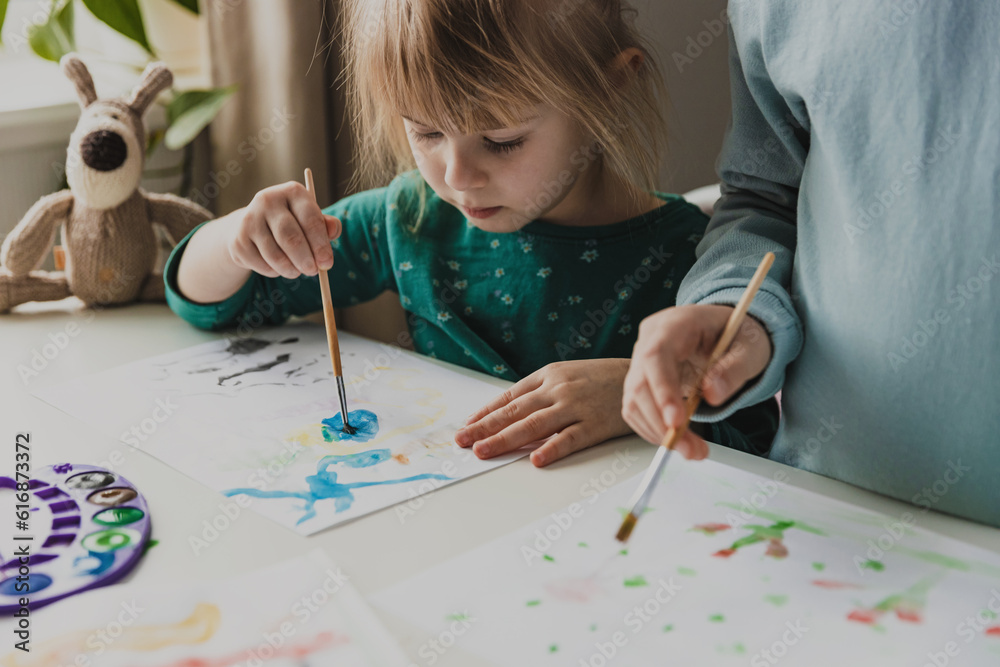 Two cute little sisters, classmates are painting on table. Small girl ...