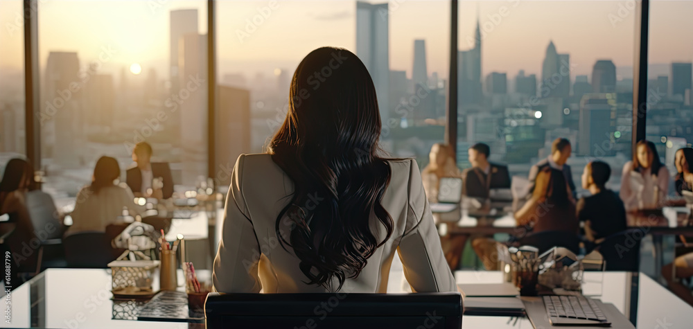 back view of women sitting apart at office table, she's working or ...