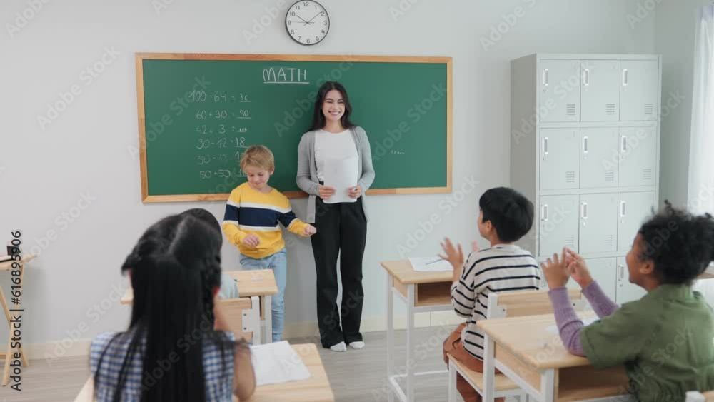 Smart Caucasian cute boy writing answer math formula on blackboard with ...