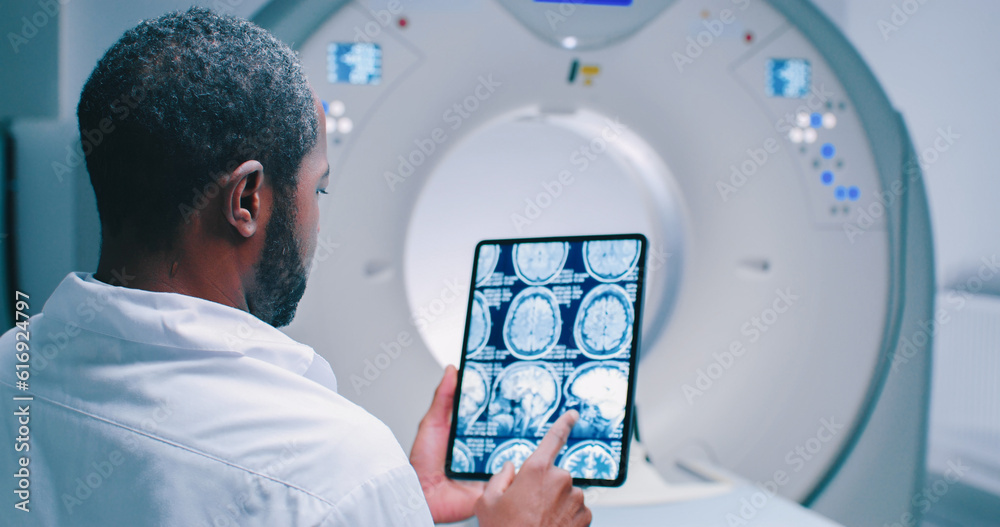 African American doctor examine scan attentively. Medical worker ...