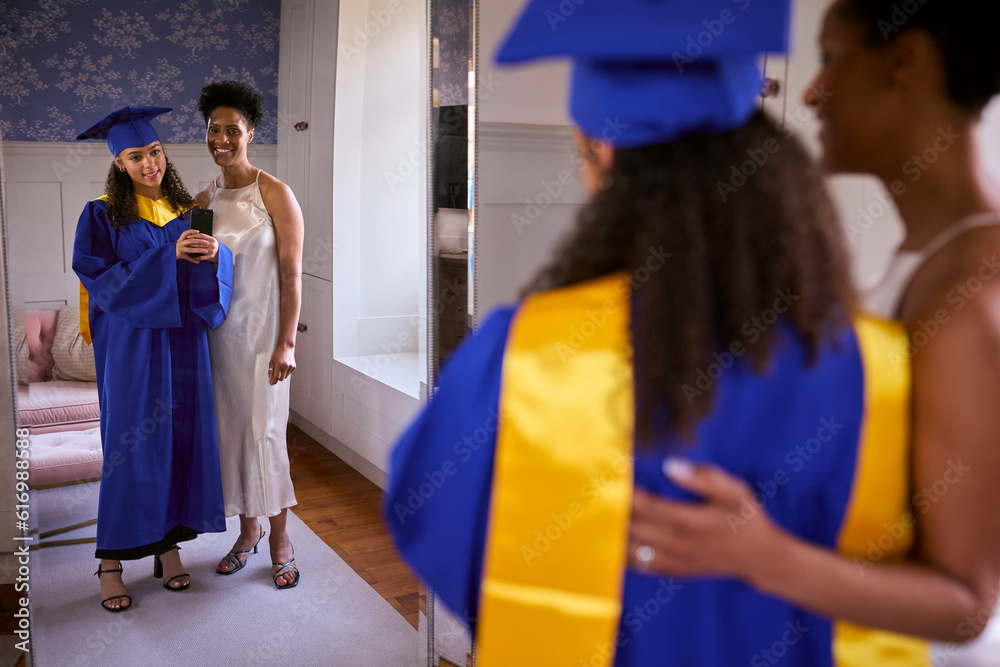 Proud Mother Celebrating With Teenage Daughter Wearing Graduation Robes ...