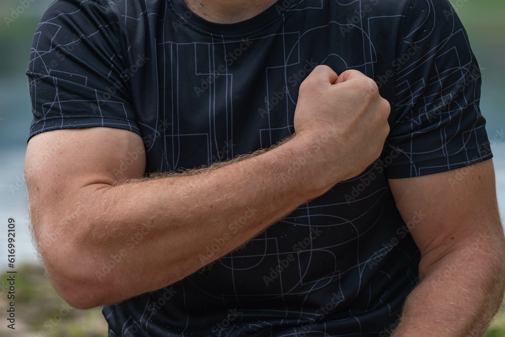 Flexing muscles close up of a fit man arm and bicep, copy space ...