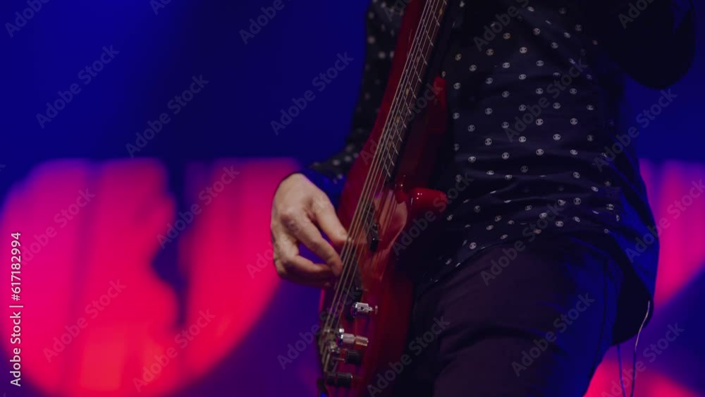 A virtuoso bass guitarist playing an electric guitar on stage with ...