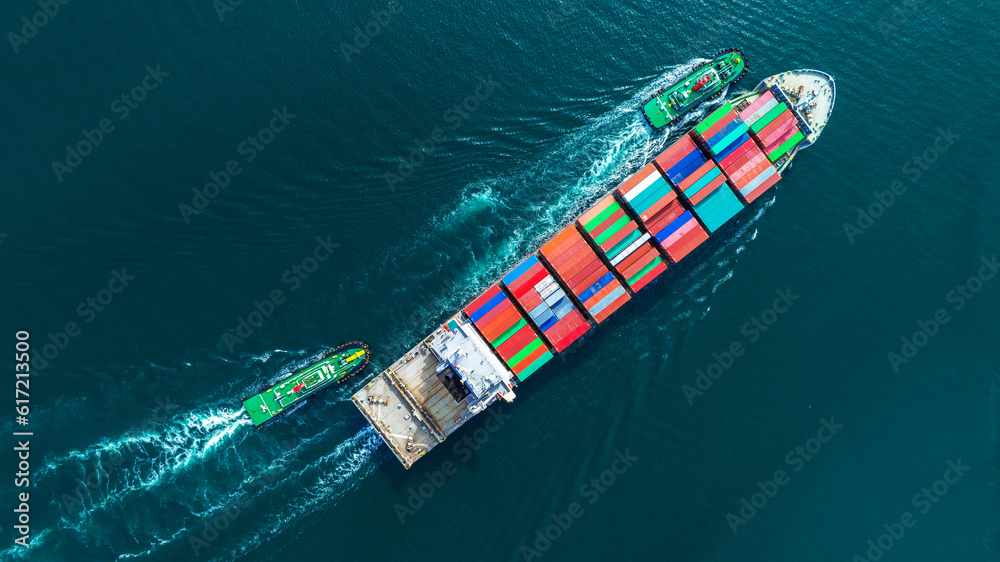 Aerial top view of cargo ship carrying container and running with tug ...