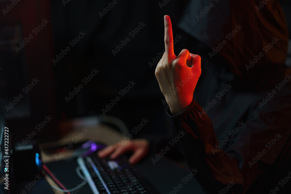 Hacker in hoodie showing middle finger and typing code to hacking ...