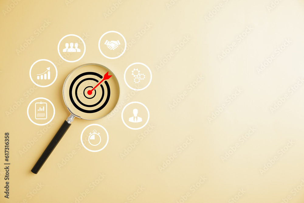 Magnifying glass focuses on target icon, representing concept of start ...