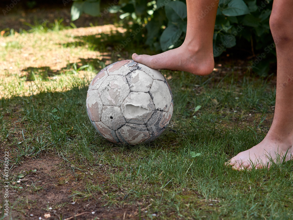 Horizontal photo. Close-up of a young girl's barefoot soccer player's ...