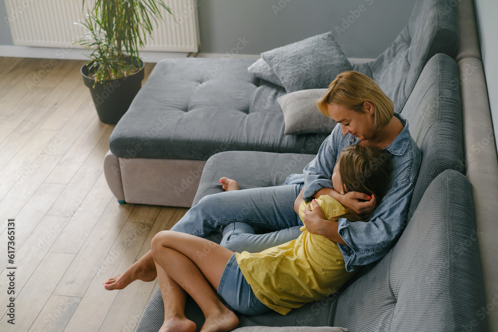 Young loving mother hugging her teenage daughter, mom demonstrating unconditional love for child ...