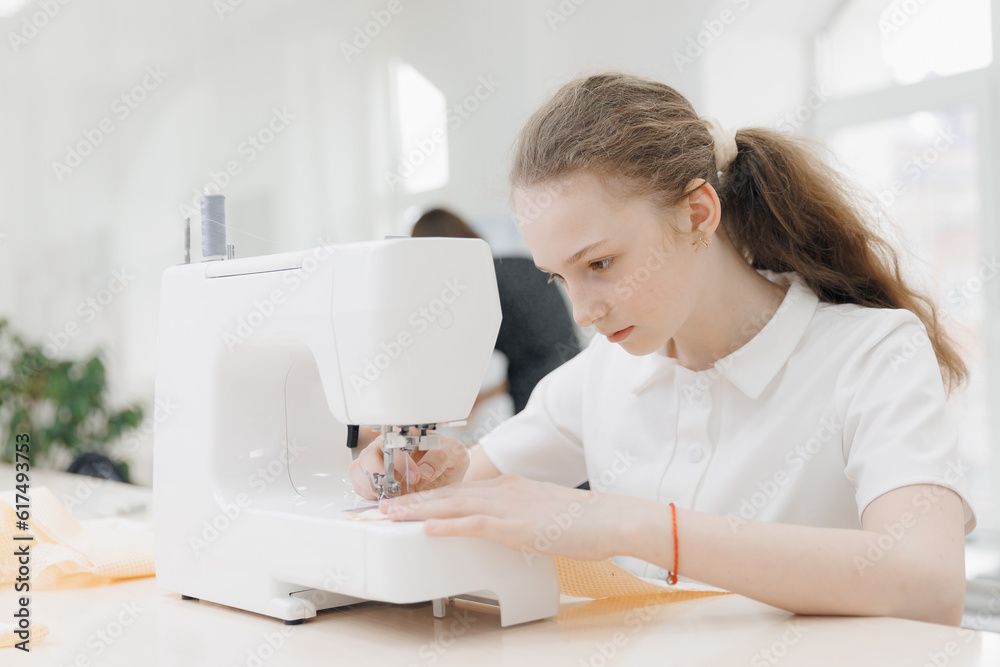 Little girl learns to sew, working with modern sewing machine on ...