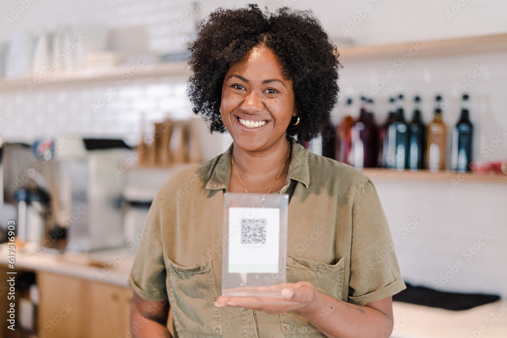 owner of a coffee shop in Brazil smiling holding a sign with a QR code ...