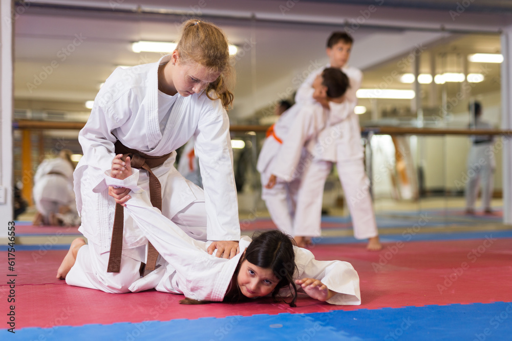Two young boys training joint lock movement during group karate ...