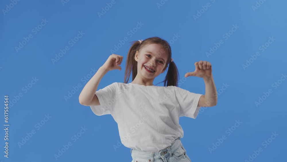 Portrait of cute little girl kid looking approvingly at camera pointing ...