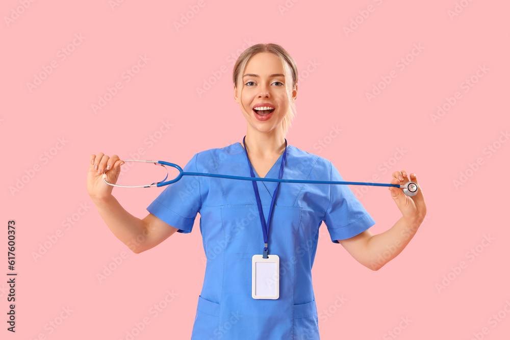 Female medical intern with stethoscope on pink background Stock Photo ...