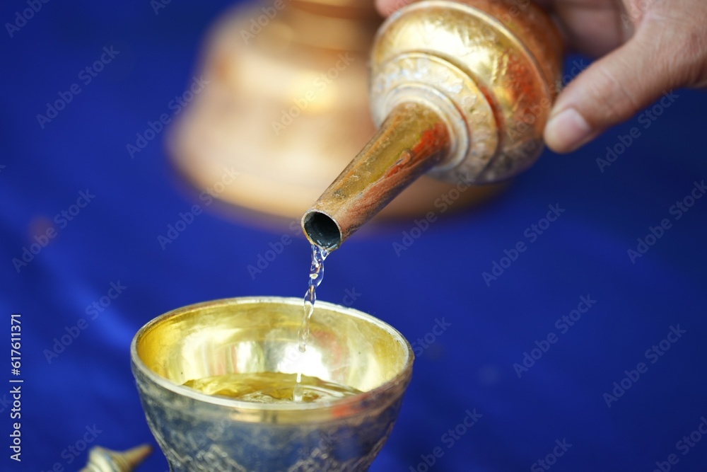 Pouring water from a copper bottle into a vessel is a tradition to ...