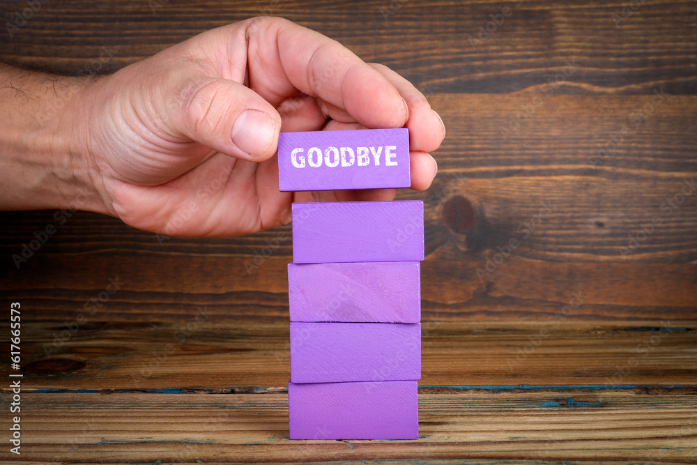 Goodbye Concept. Purple blocks with text in a pile on a wood texture ...
