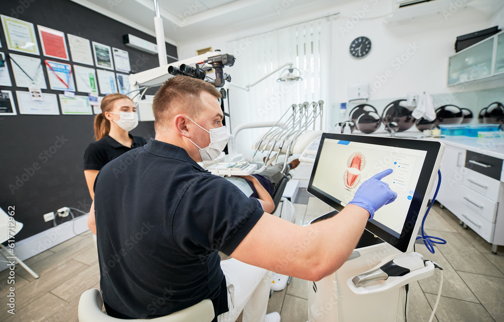 Dentist scanning patient's teeth with modern machine for intraoral ...