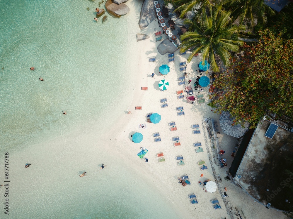 Stunning beach area with people basking in the sun separated by crystal ...
