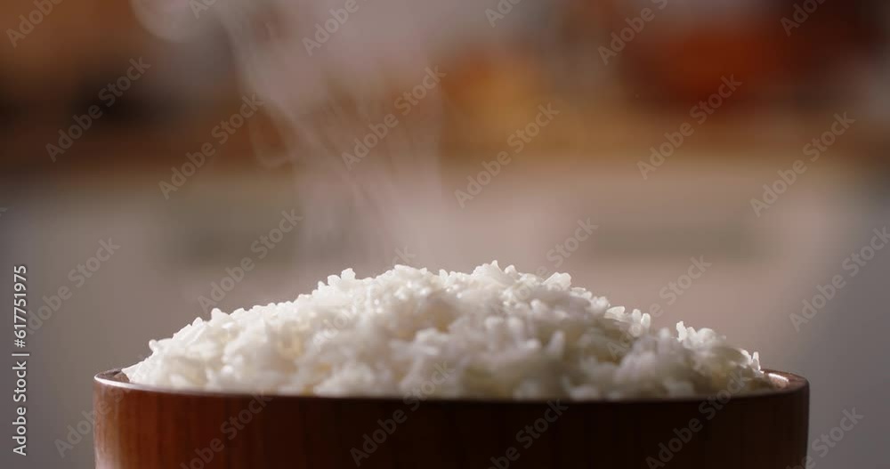 Hot white cooked rice steam bowl blurred kitchen background. Sticky ...