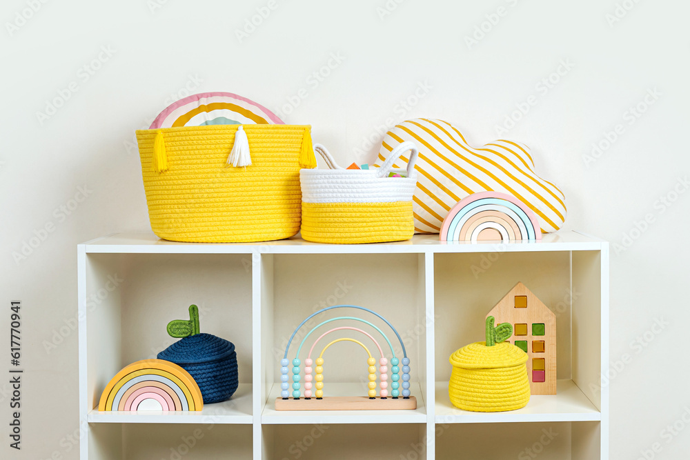White shelving with rainbow wooden toys and colorful storage baskets ...
