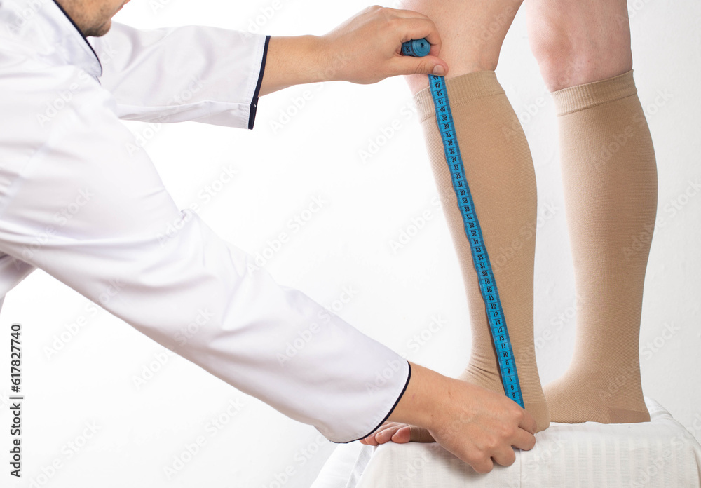 Doctor phlebologist - a vascular surgeon selects the size of the ...