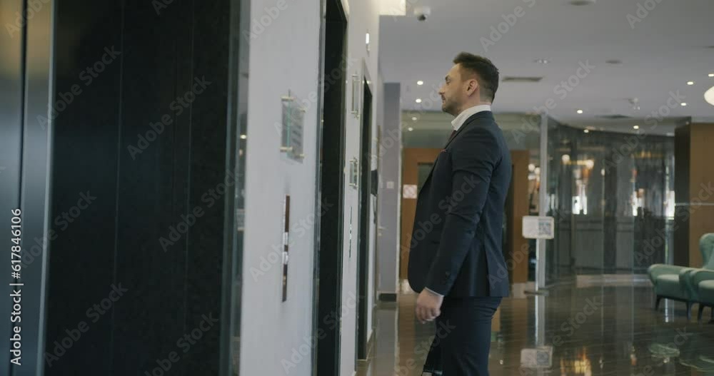 Side view of successful young businessman waiting for elevator in ...