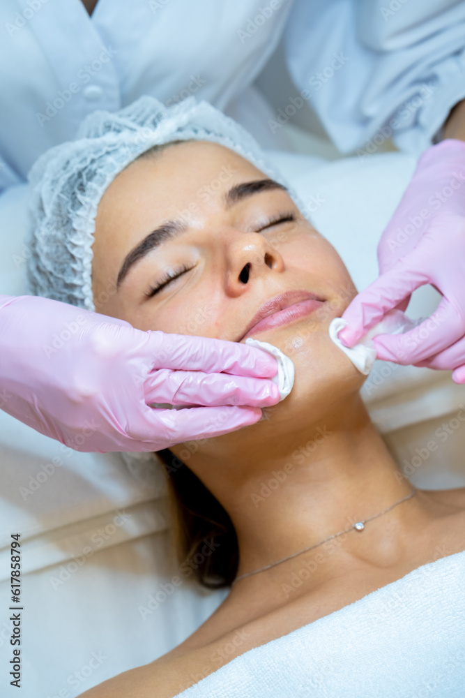 Beautician doctor cleaning woman face with cotton pads, skin care ...